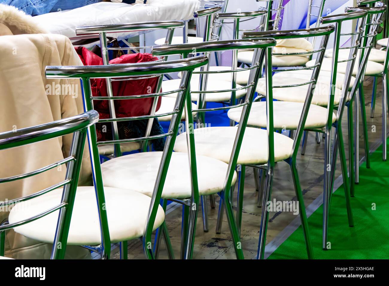 Chrome and white chairs neatly aligned in an indoor event space ...