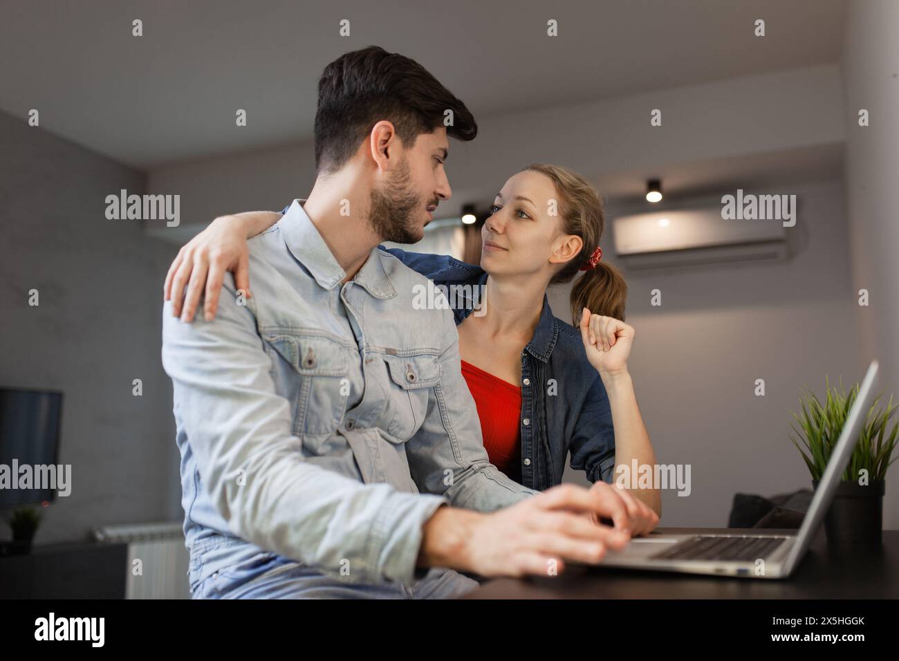 A young man and woman share a tender gaze, showing affection and ...