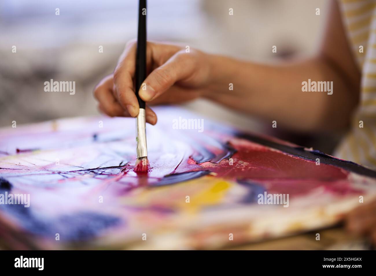 Hand using brush on an artistic painting. Female artist creating art ...