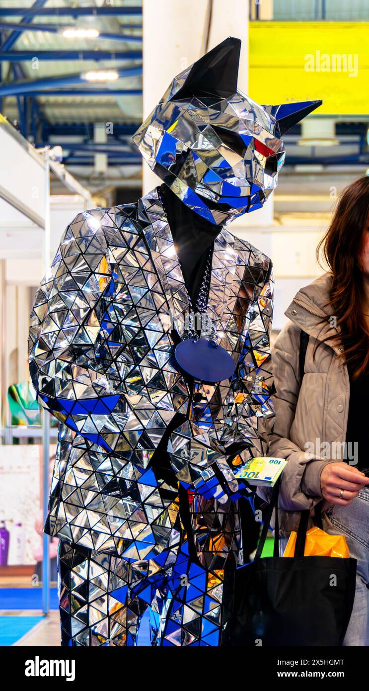 A man in a reflective mirror cat suit poses for a photo shoot with a ...