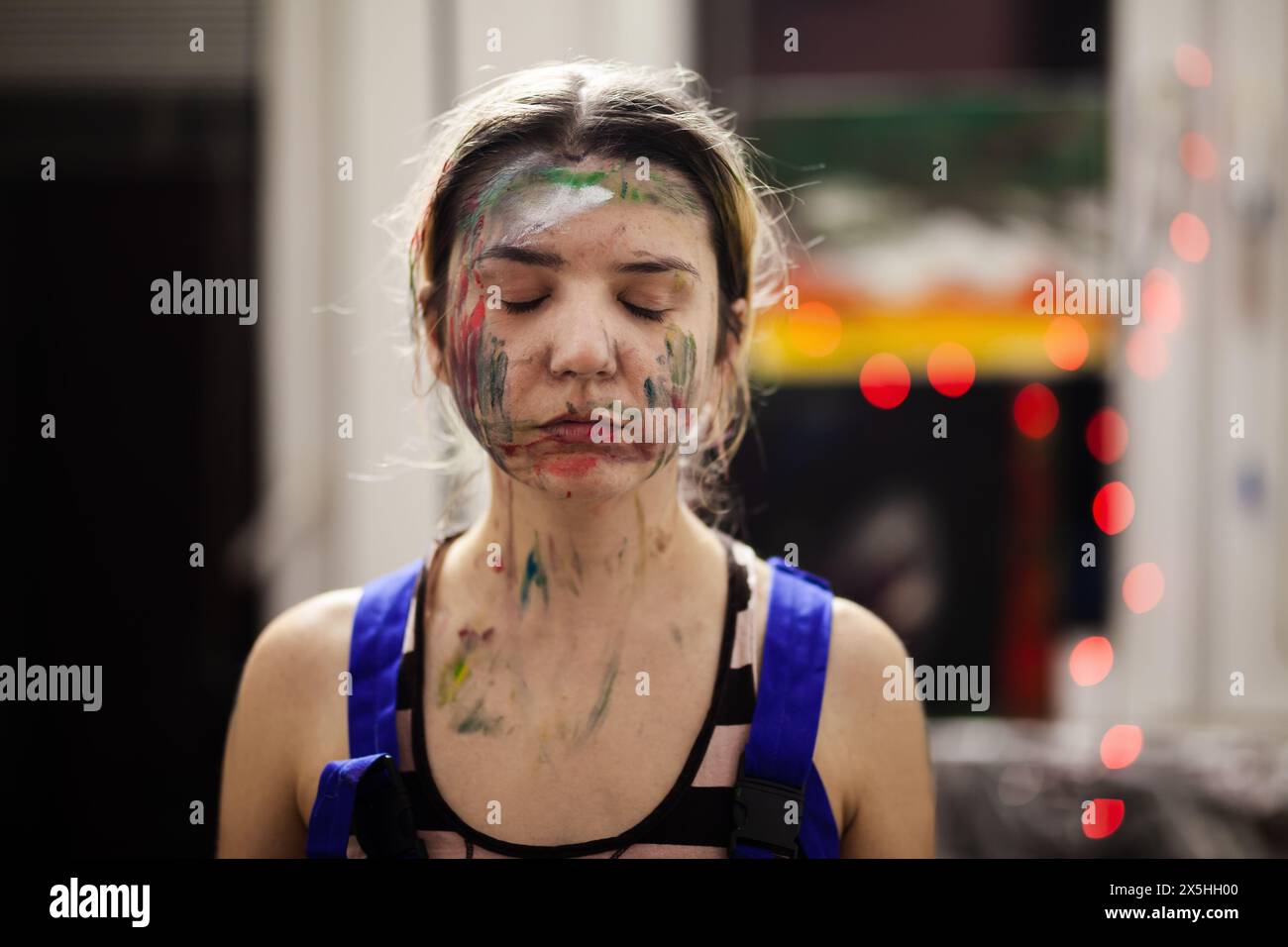 Portrait of a female artist. Girl with clumsy clorful painted face ...