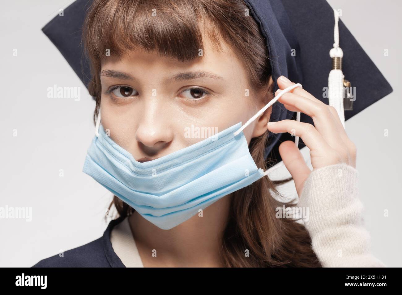 Graduation girl wearing gown and cap. Female student putting on ...