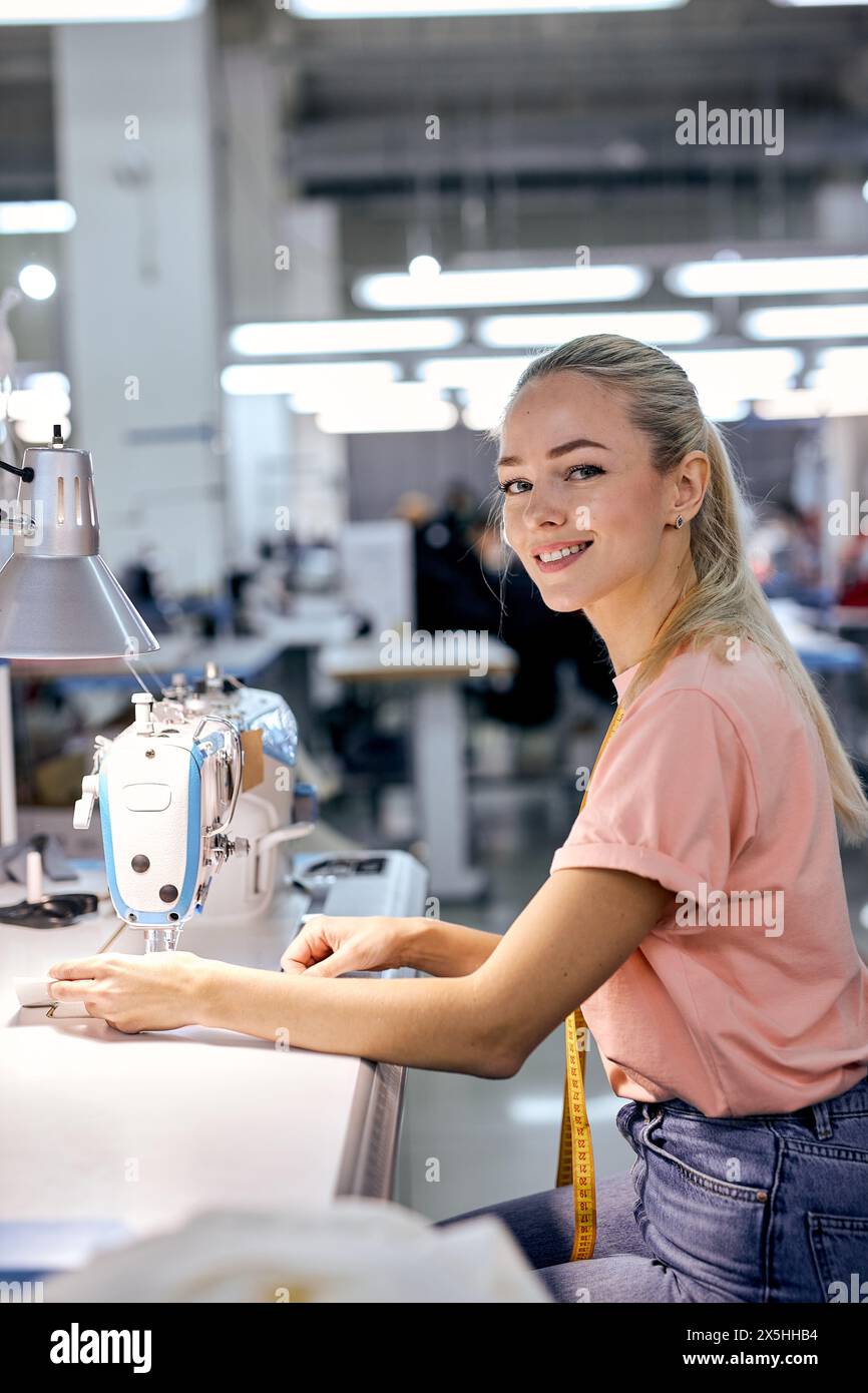 young nice caucaian blonde textile factory worker on production line ...