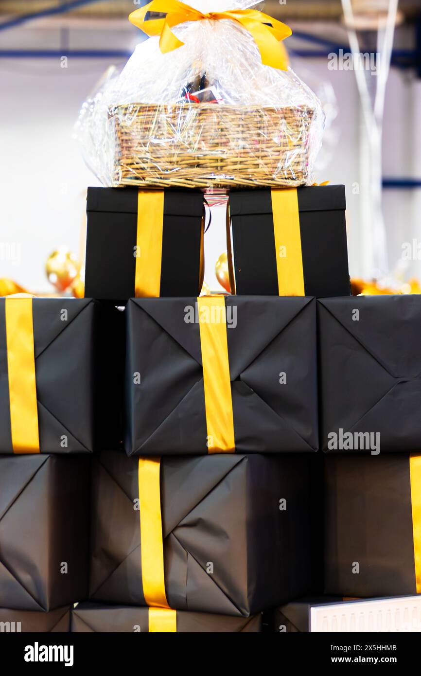 Black and yellow gifts stacked on top of each other. Several black ...