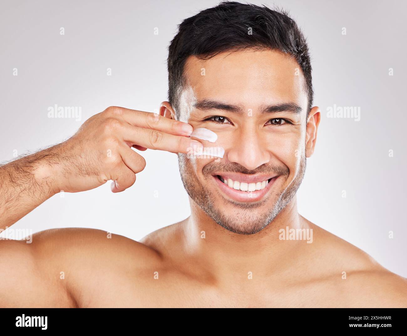 Face, portrait and asian man with lotion in studio for skin hydration ...