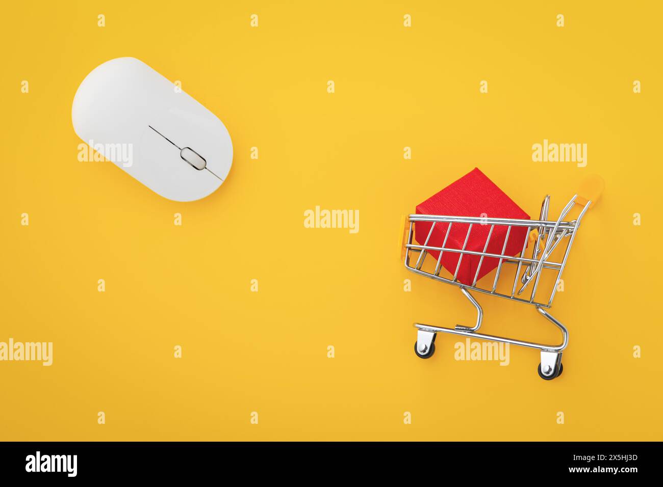 Wireless mouse with shopping cart on yellow background, online shopping ...