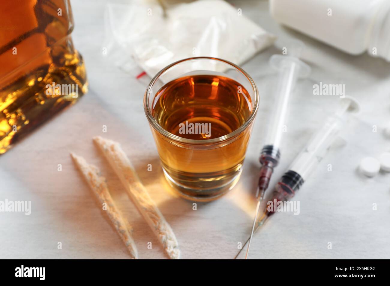 Alcohol and drug addiction. Whiskey in glass, syringes and cocaine on ...