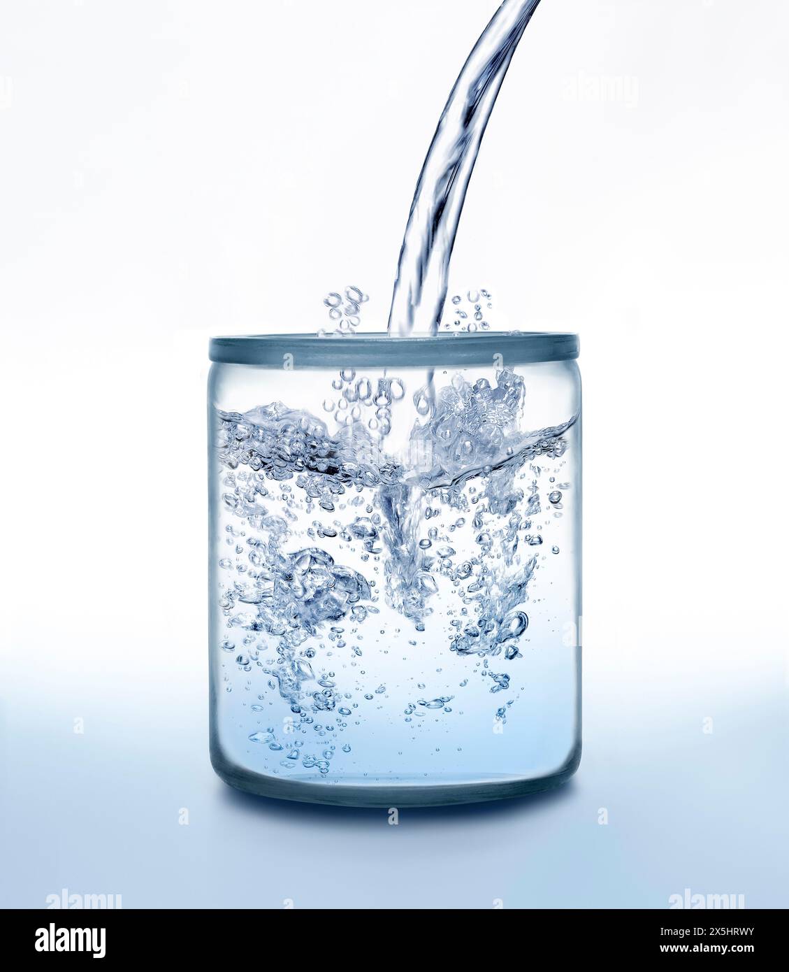 Water jet splashing into a glass jar against white and blue color Stock ...