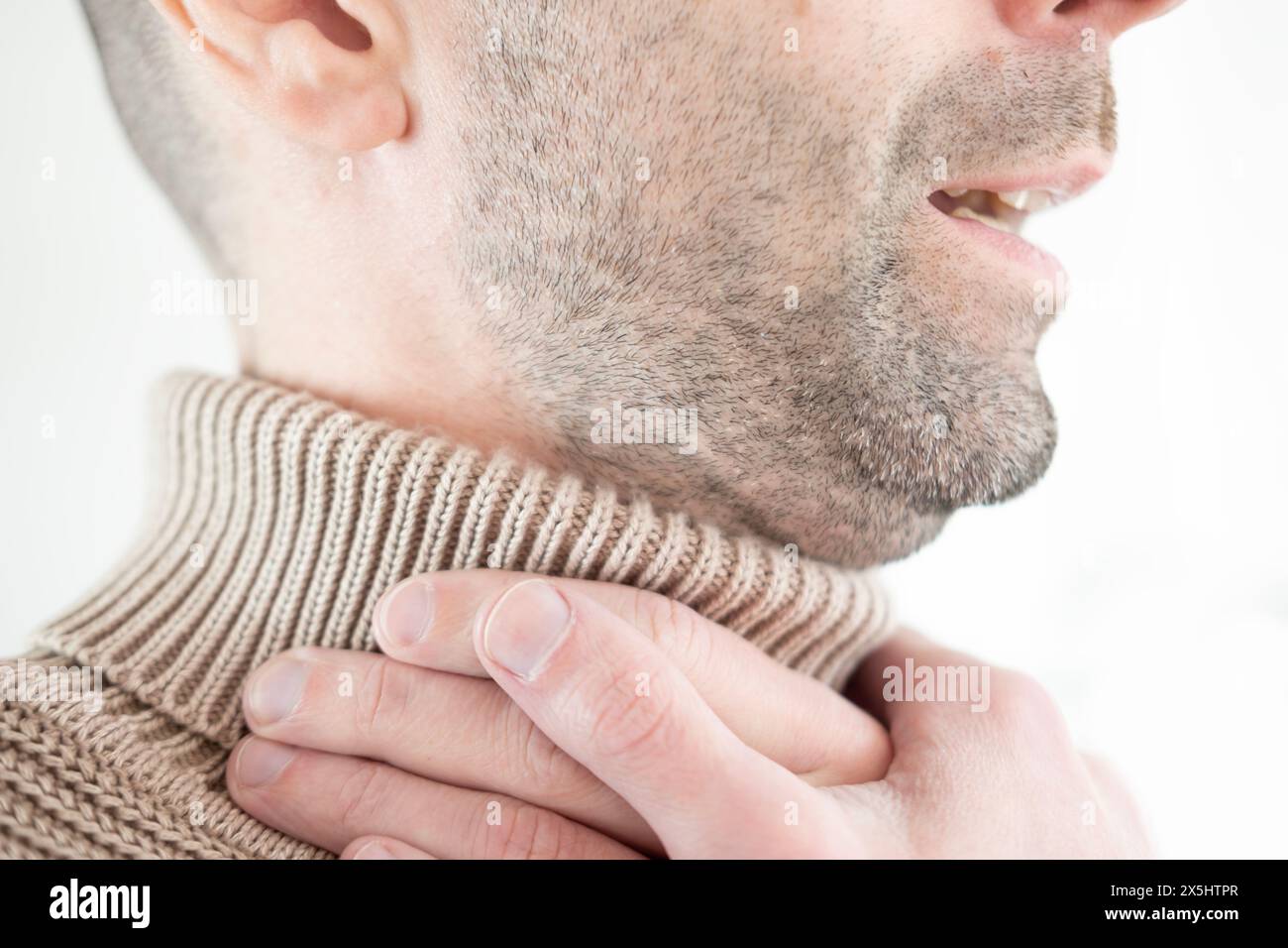 close-up young male neck, man patient holding affected area ...