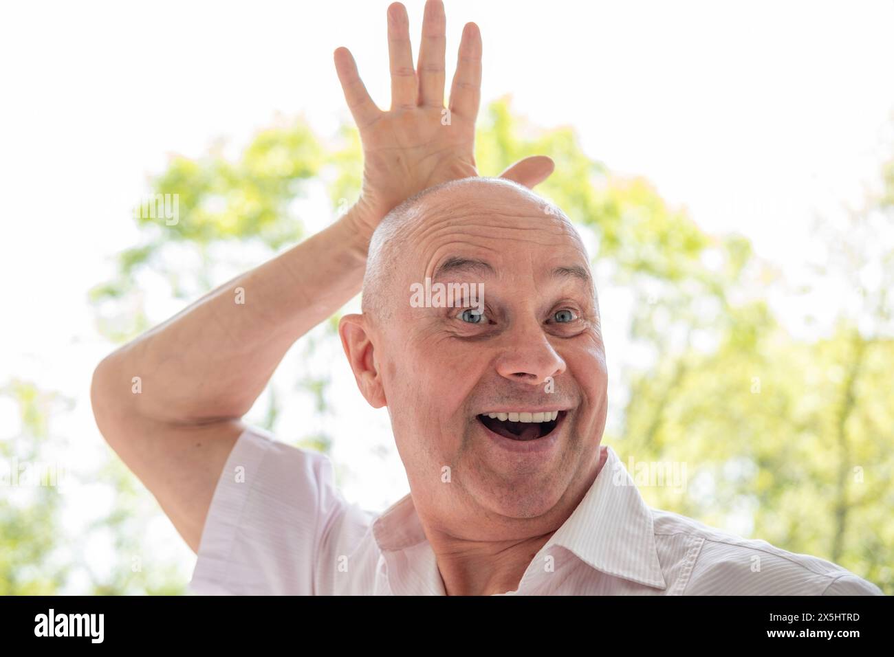 65-year-old eccentric man, senior showing grimaces, winks, mischievous ...