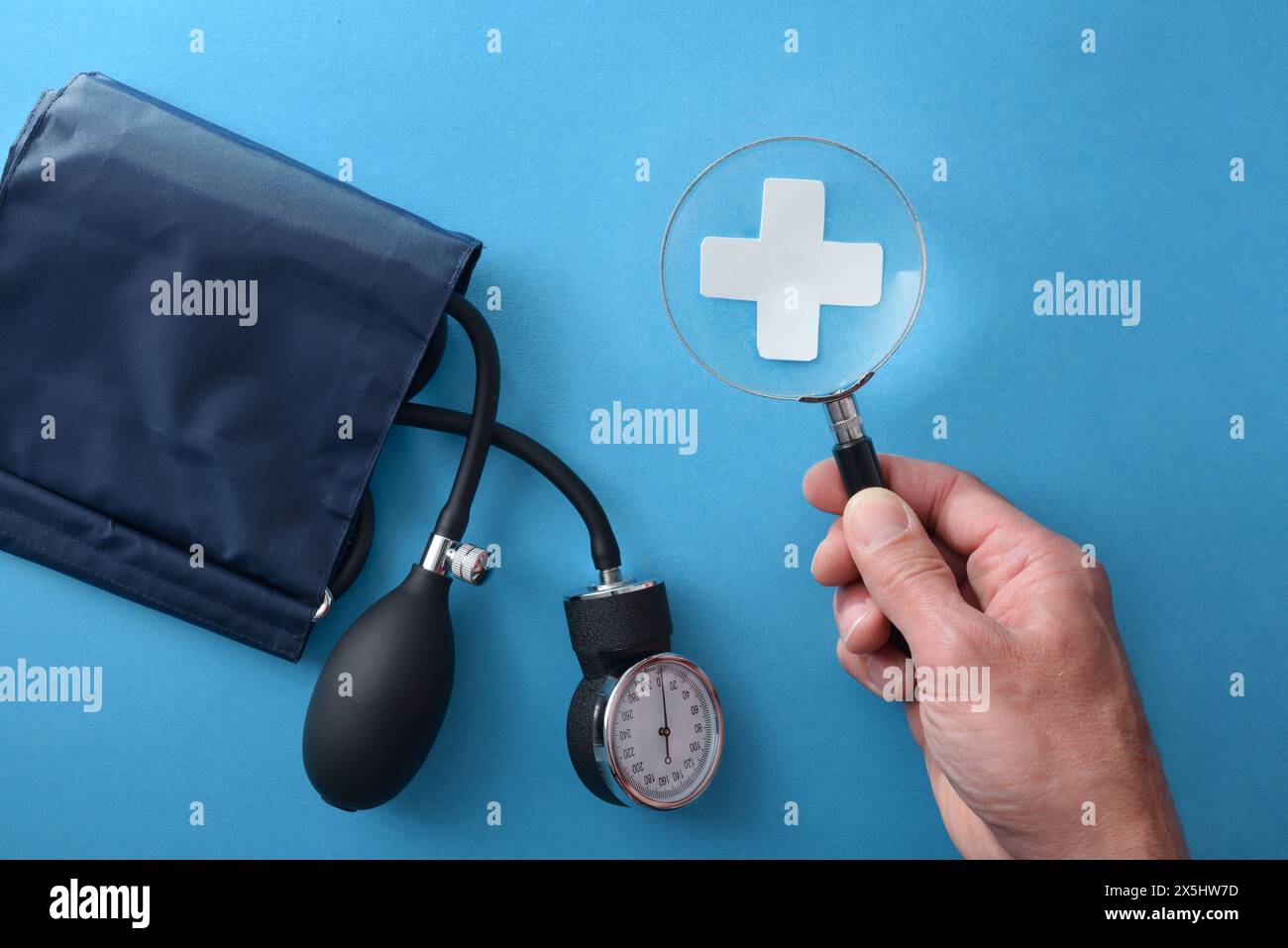 Blood pressure diagnosis concept with hand and magnifying glass on ...