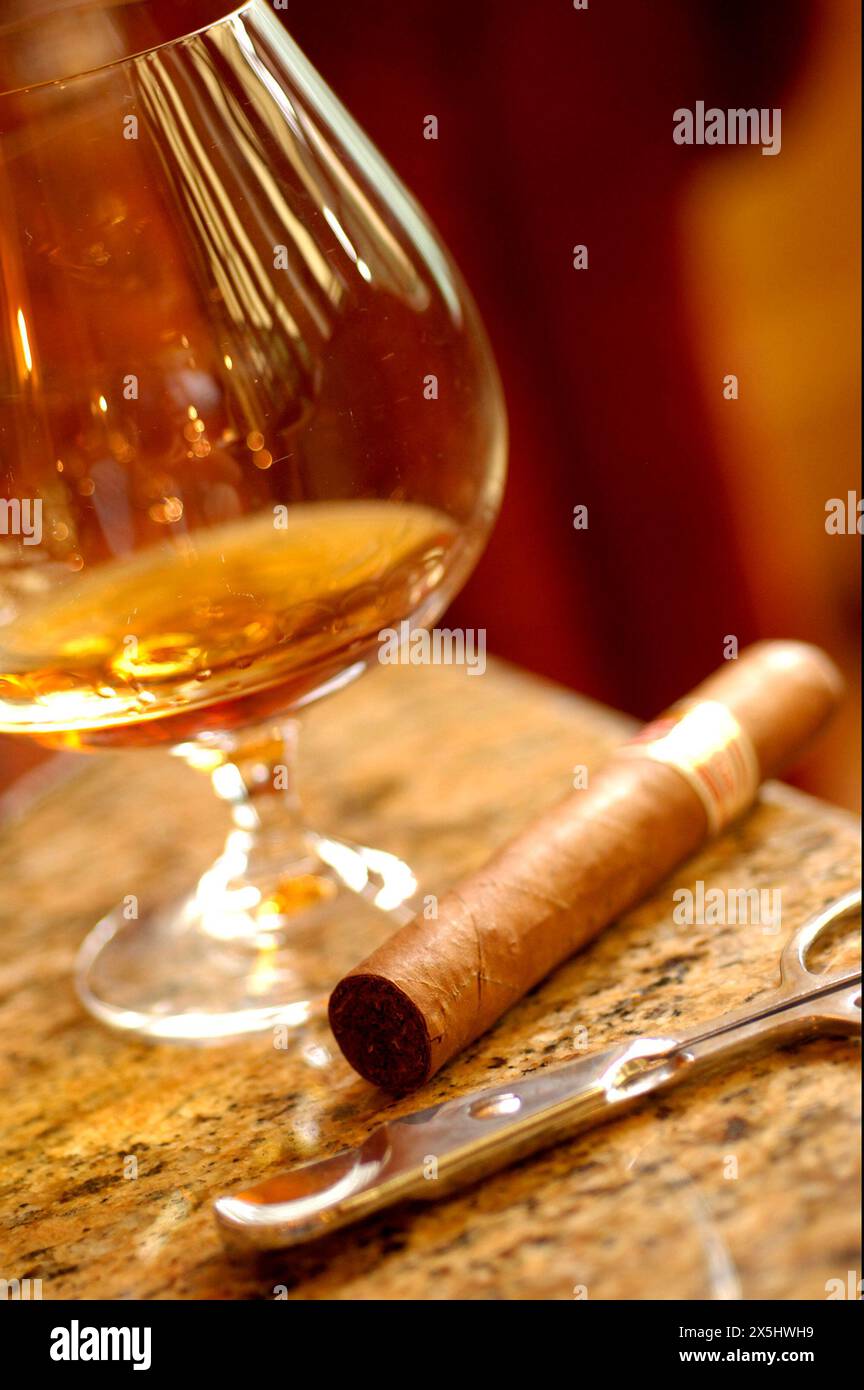 Cigar Brandy glass and cigar cutters on marble table top Stock Photo ...