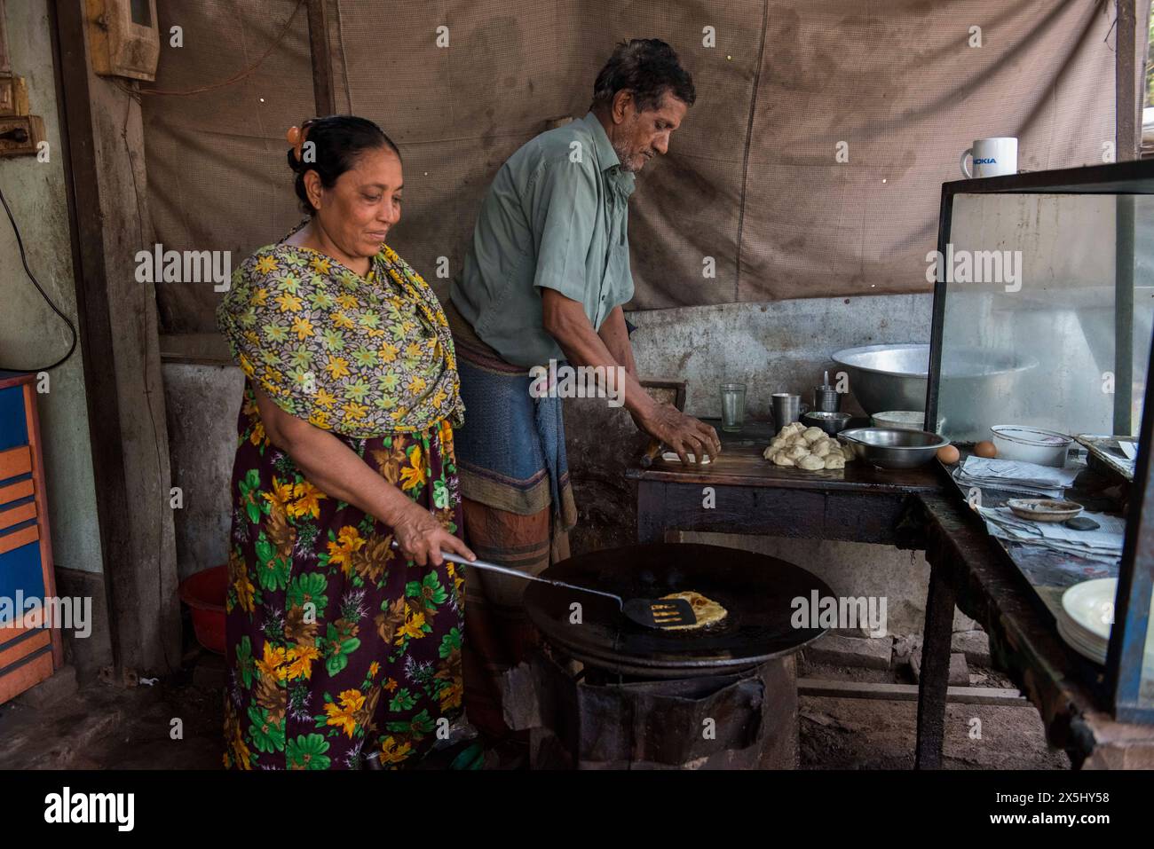 Bangladesh, Jhenaidah. A woman cooks in their roadside restaurant making lentils. (Editorial use ...
