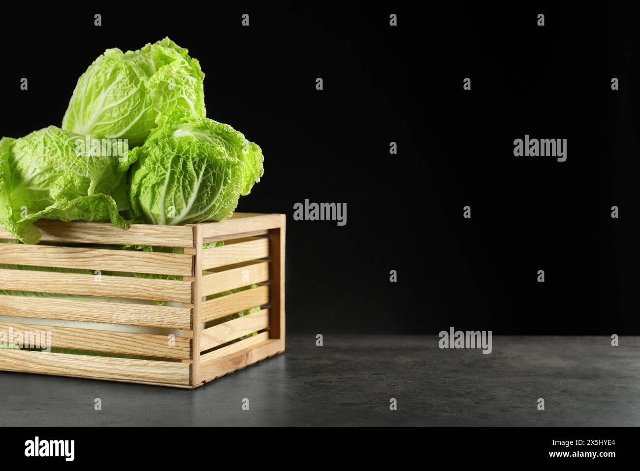Fresh ripe Chinese cabbages in wooden crate on grey table, space for ...