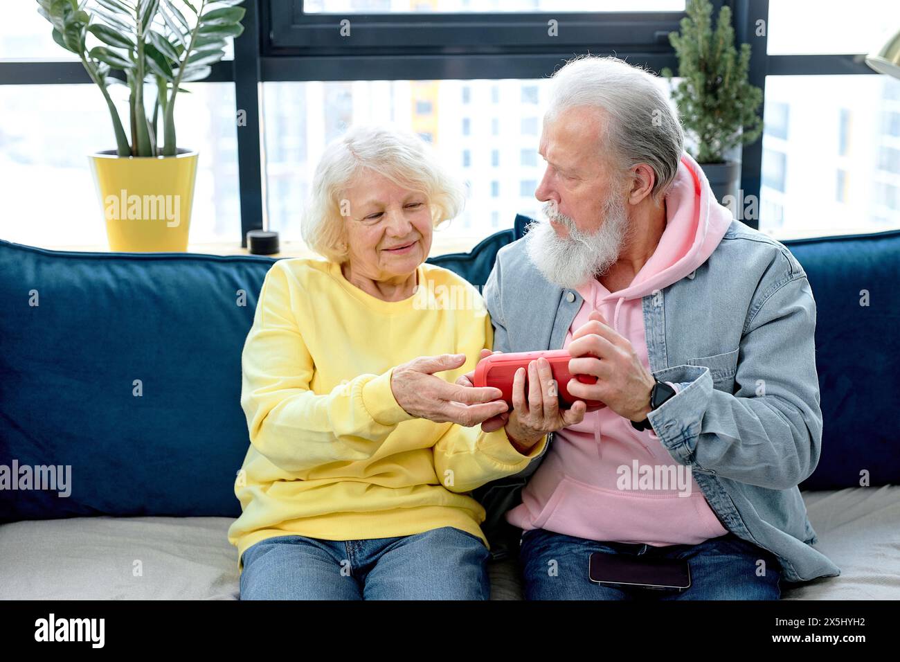 nice mature couple using a Virtual Assistant music loud speaker at home ...