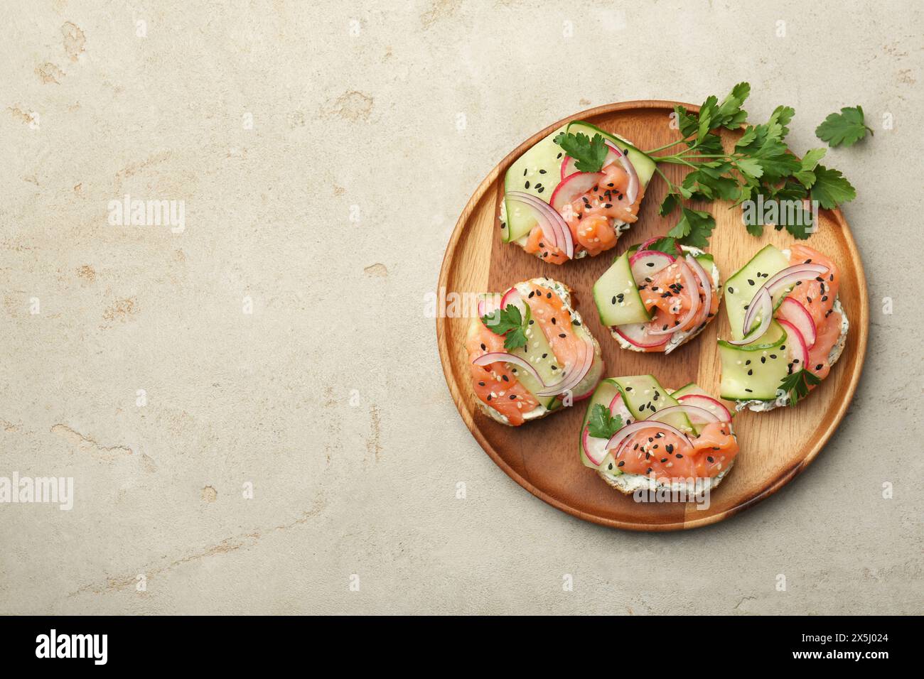 Tasty canapes with salmon served on light grey table, top view. Space ...