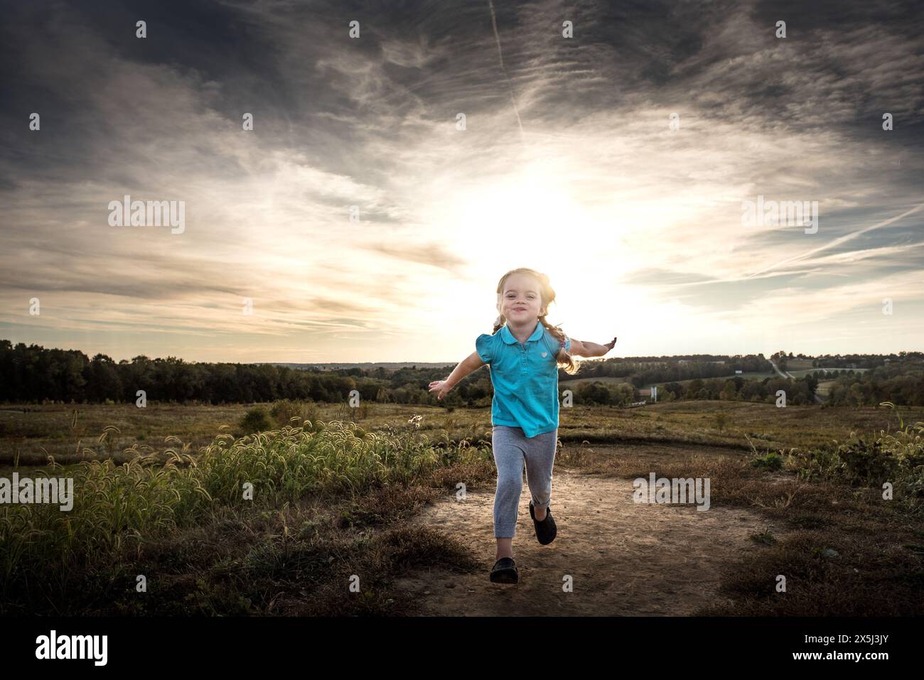 Little girl with braids running with arms out Stock Photo - Alamy