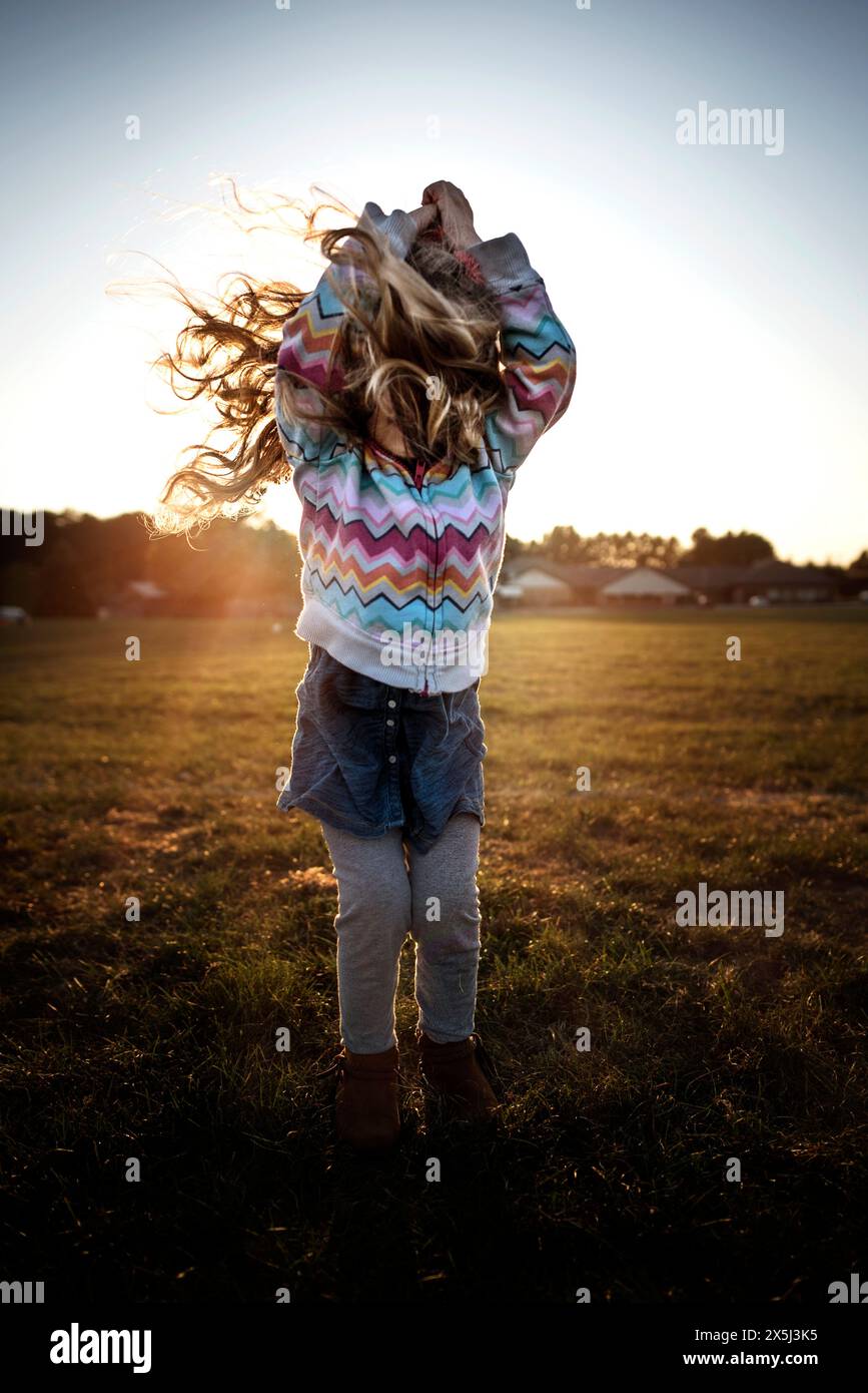 Little girl with long curls blowing in wind Stock Photo - Alamy