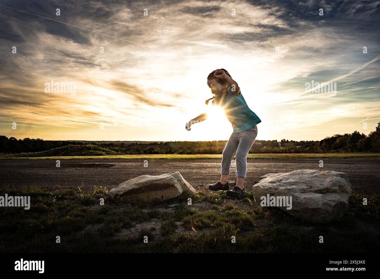 Child jumping across rocks hi-res stock photography and images - Alamy