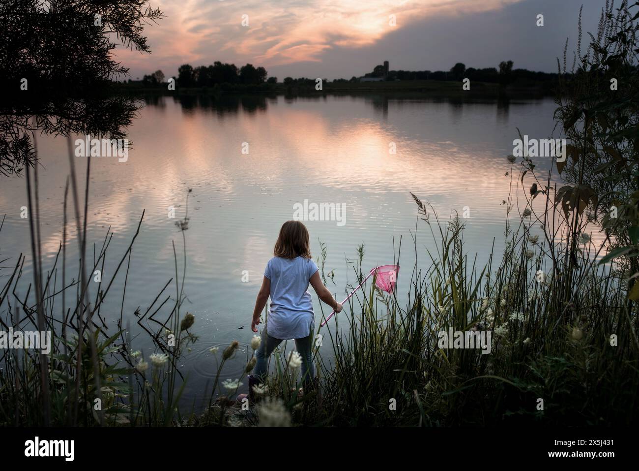 Tween girl exploring beautiful lake at sunset Stock Photo - Alamy