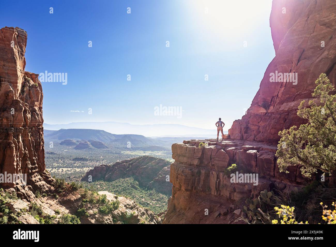 Woman hiker looks out atop Mountain summit, embodying accomplishment ...