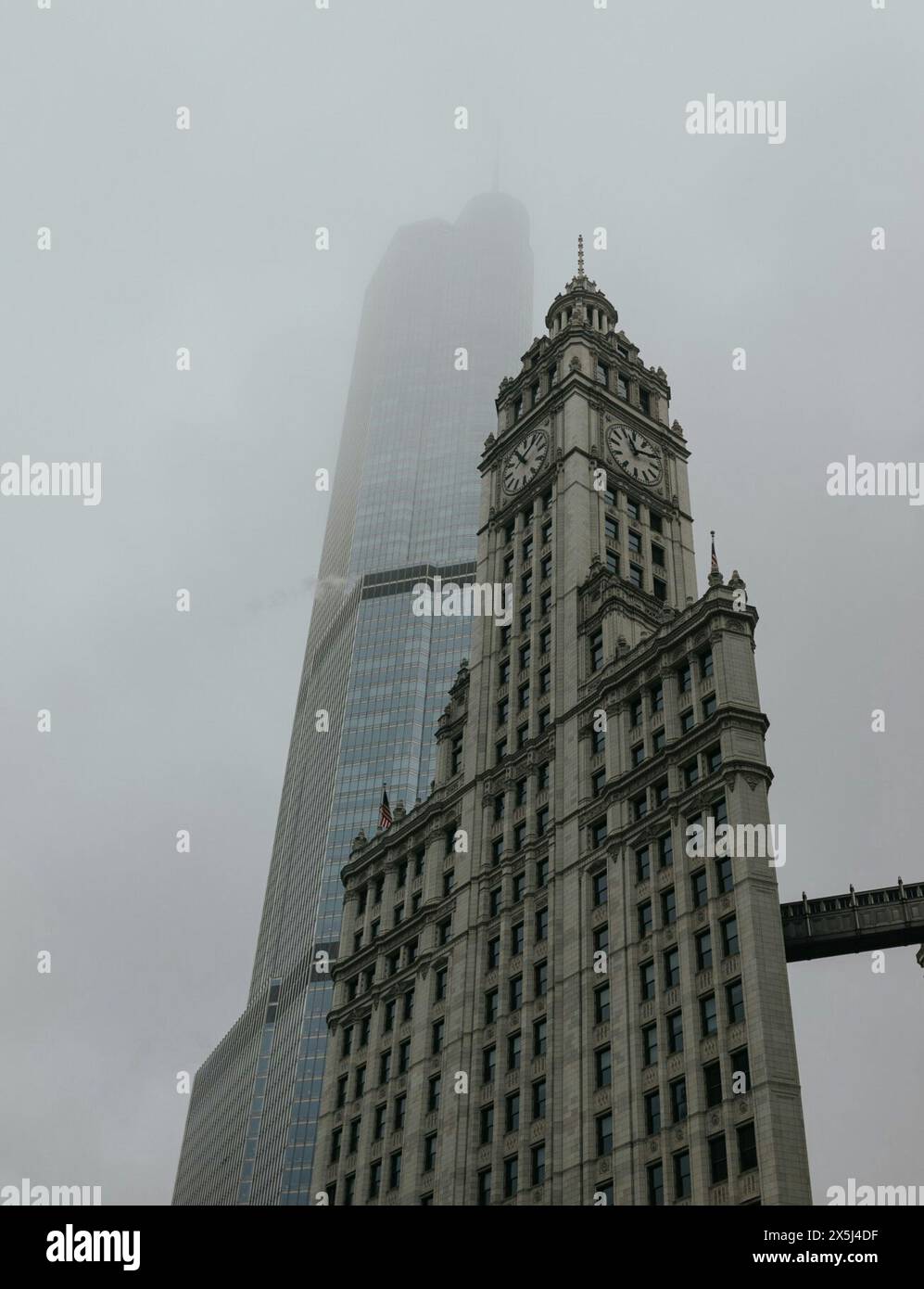 Foggy view of the Wrigley Building with a modern skyscraper in Chicago ...