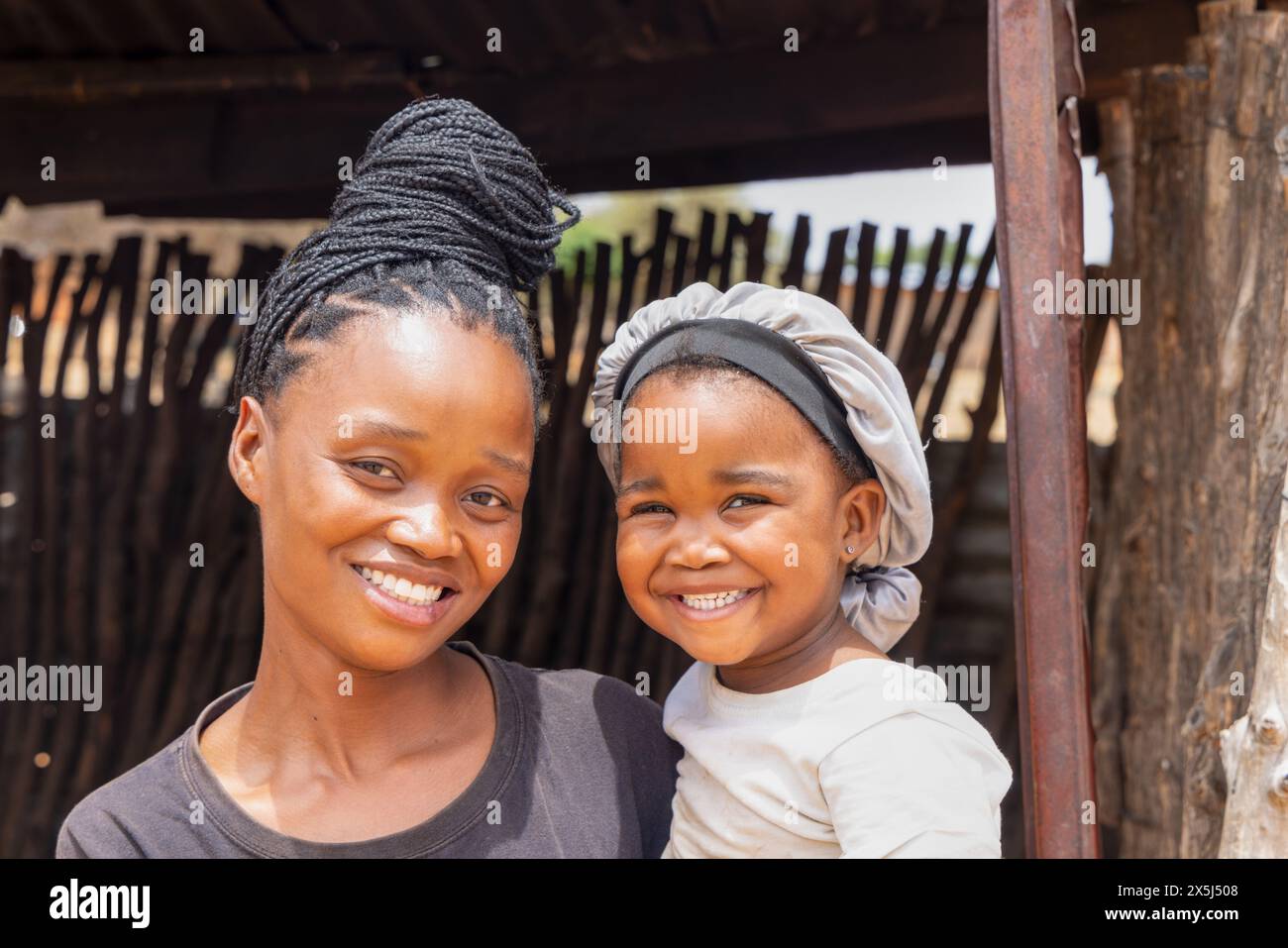 village african mother and baby standing at the entrance of the shack ...