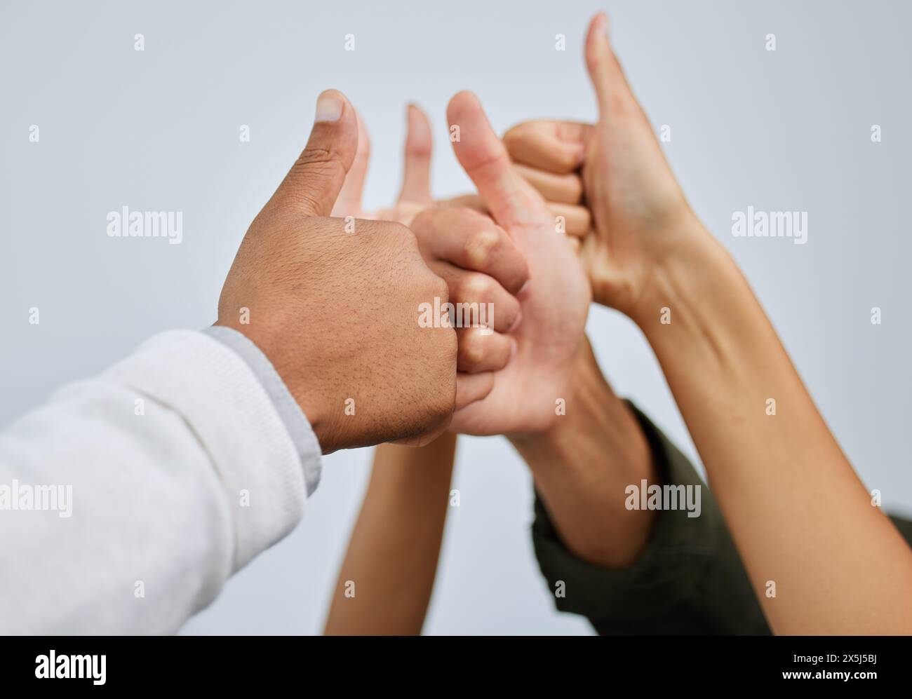 Thumbs up, hands together and team of people in studio with unity ...