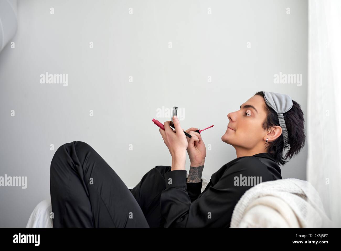 fashion elegant guy applying makeup in the living room. close up side ...