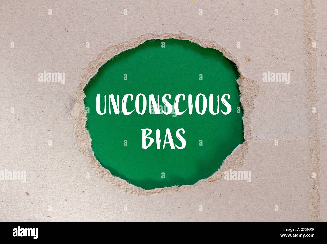 Unconscious bias words written on ripped paper with green background. Conceptual unconscious ...