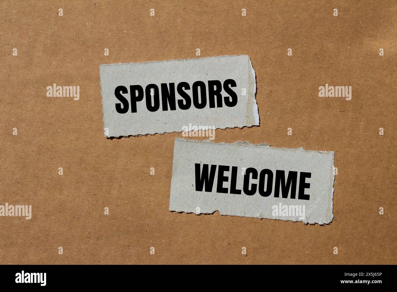 Sponsors welcome words written on ripped paper pieces with brown ...
