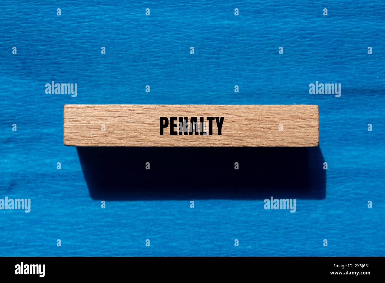 Penalty word written on wooden block with blue background. Conceptual ...