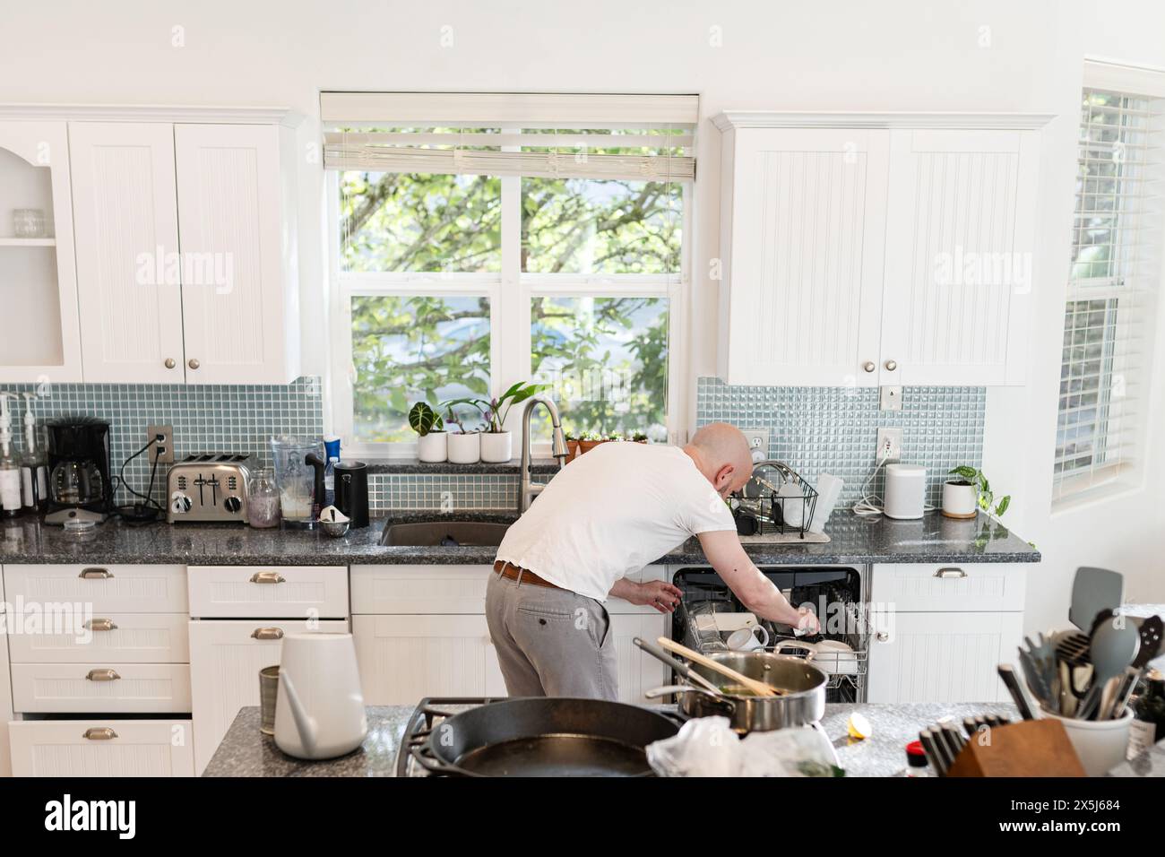 Man doing dishes at kitchen sink Stock Photo - Alamy