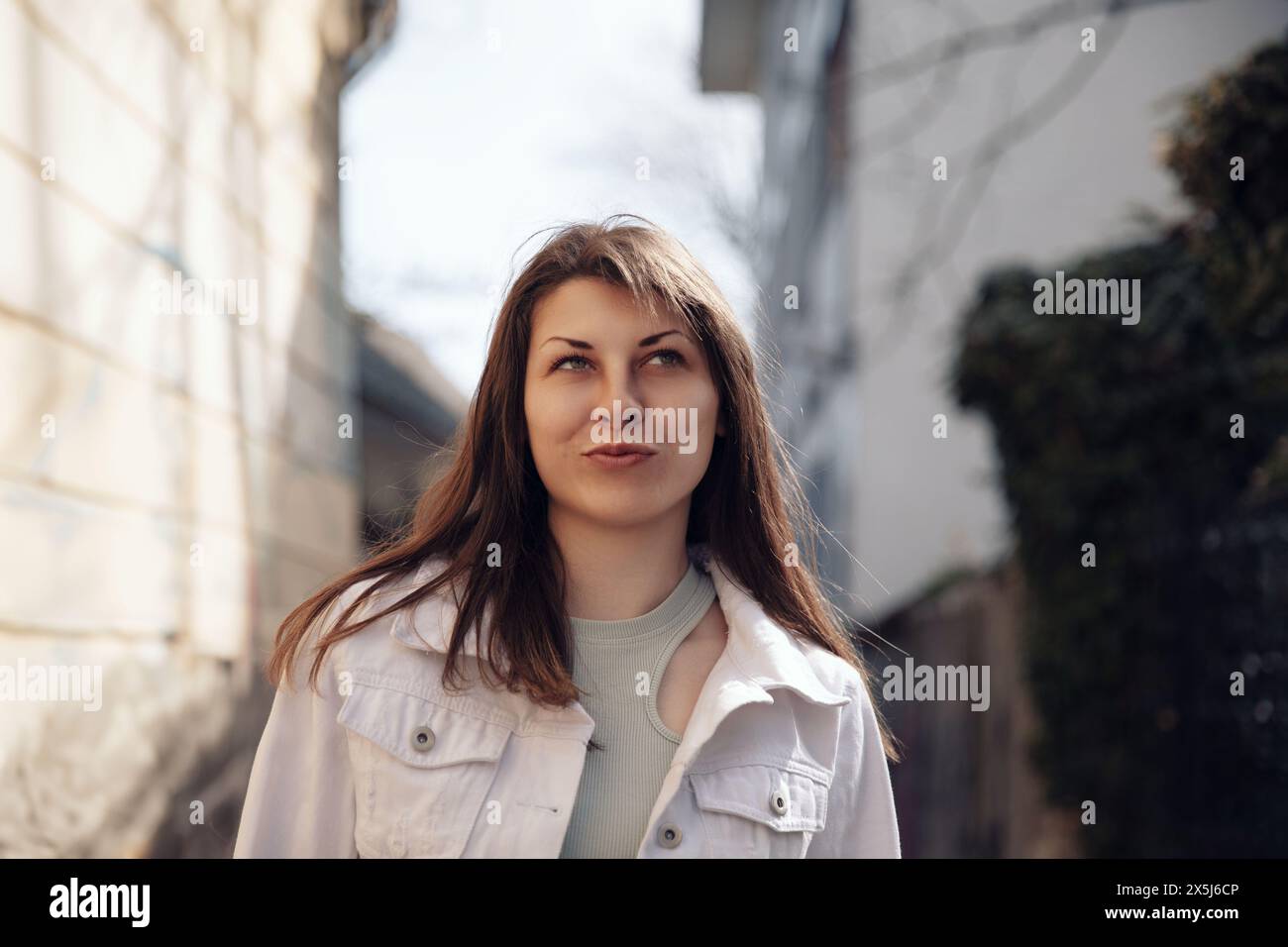 Casual Young Woman Making a Playful Face Walking in an Urban Alley ...