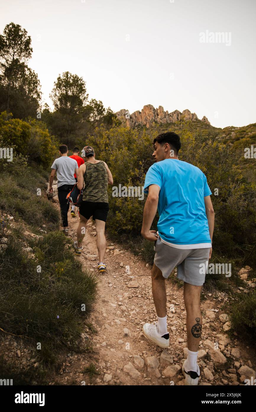 Young hiking friends doing a mountain route together Stock Photo - Alamy