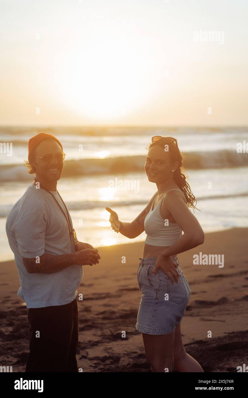 Friends talking on the beach by the ocean Stock Photo - Alamy