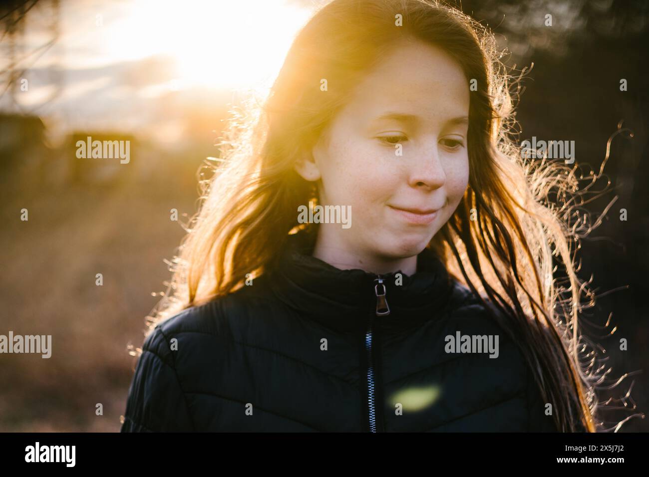Golden sunset hits blond hair of tween girl outside in spring Stock ...