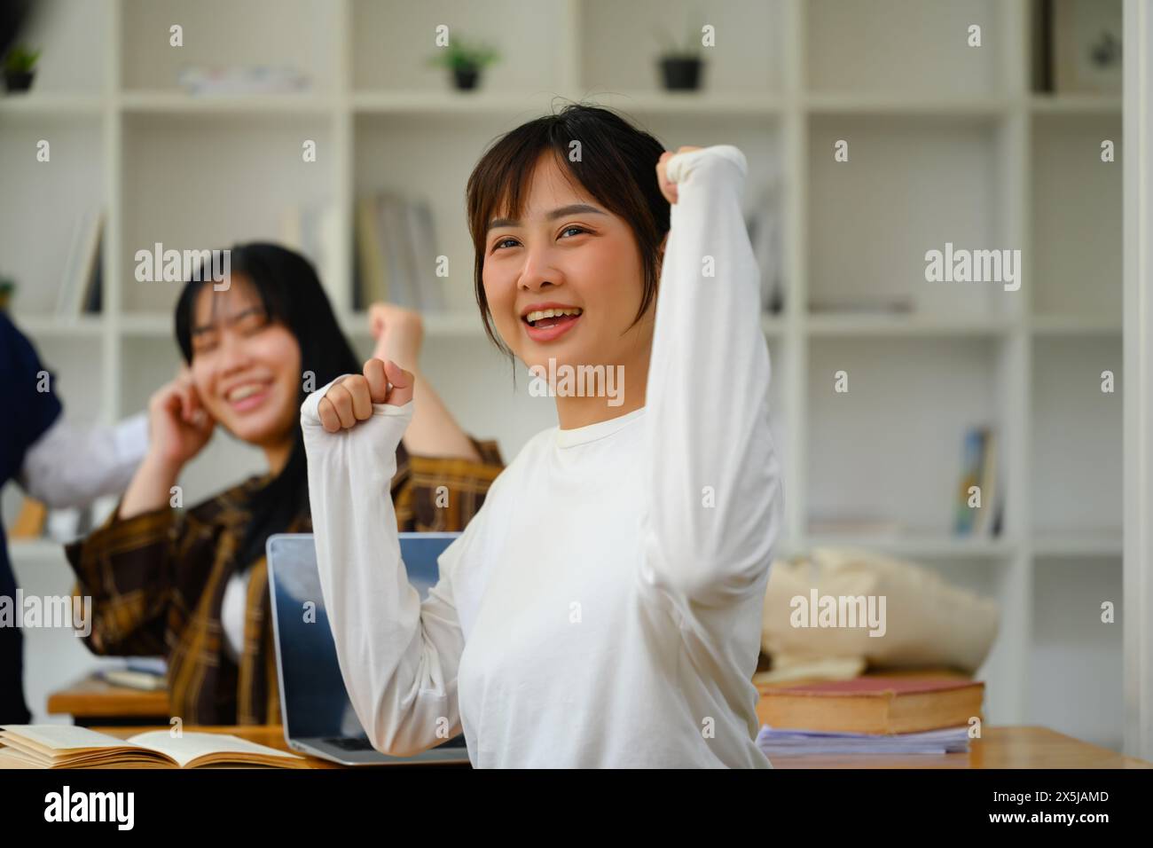 Young woman student feeling excited celebrating project success in the ...