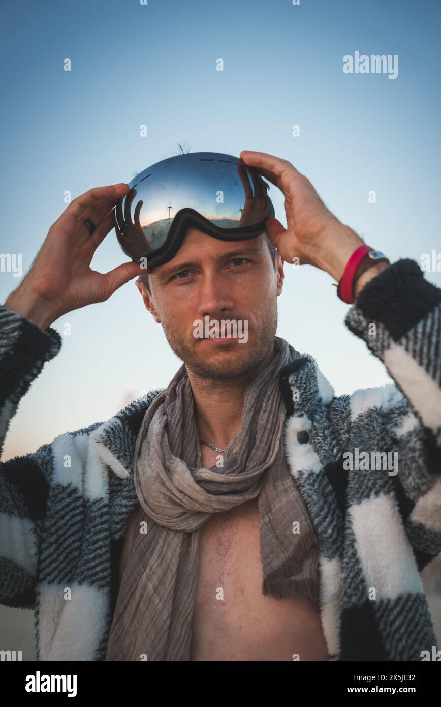 Man in Desert Setting Adjusting Reflective Goggles, Festival Vibe Stock ...
