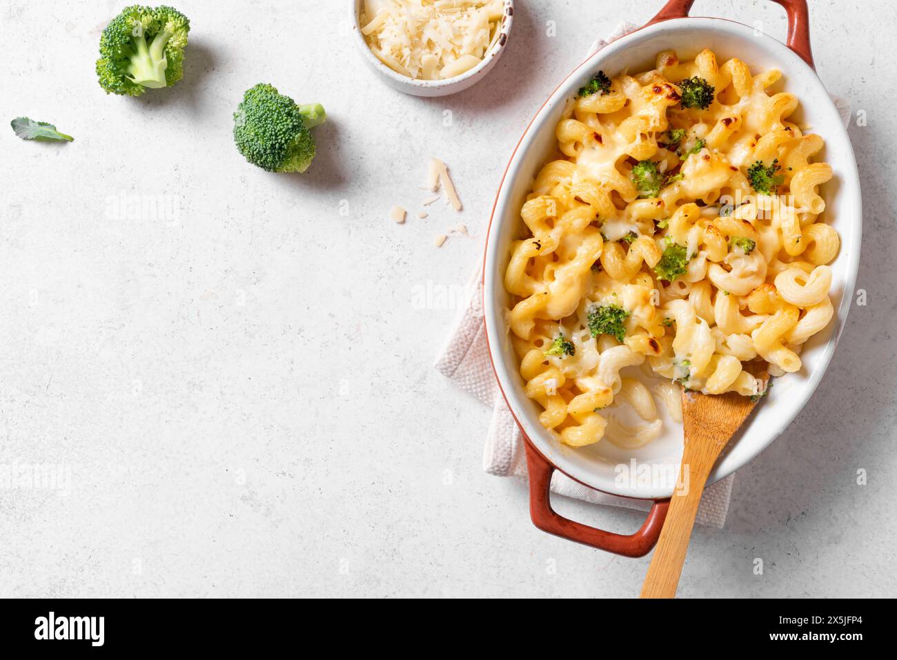 Mac and cheese with broccoli and parmesan oven baked on white background, top view, copy space ...