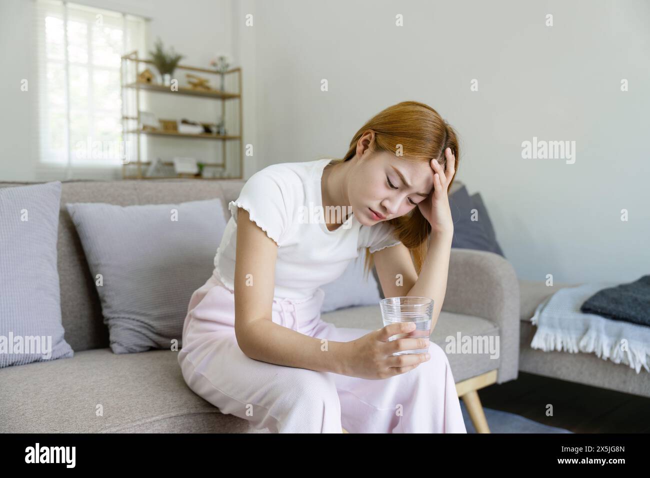 Unhappy sick young asian woman suffer from terrible head pain. touching ...