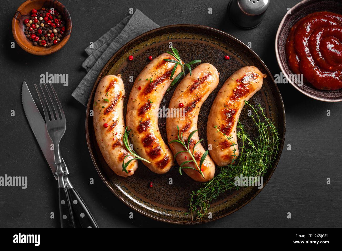 Grilled sausages with tomato sauce on black background. Roasted ...