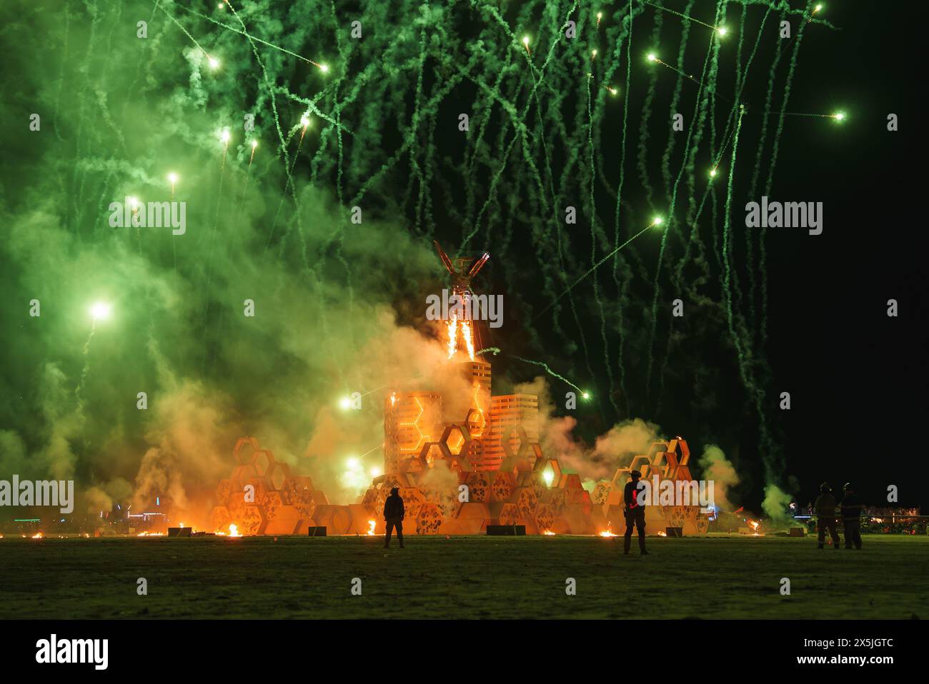 Vibrant Night Scene with Fireworks and Burning Structure in Desert ...