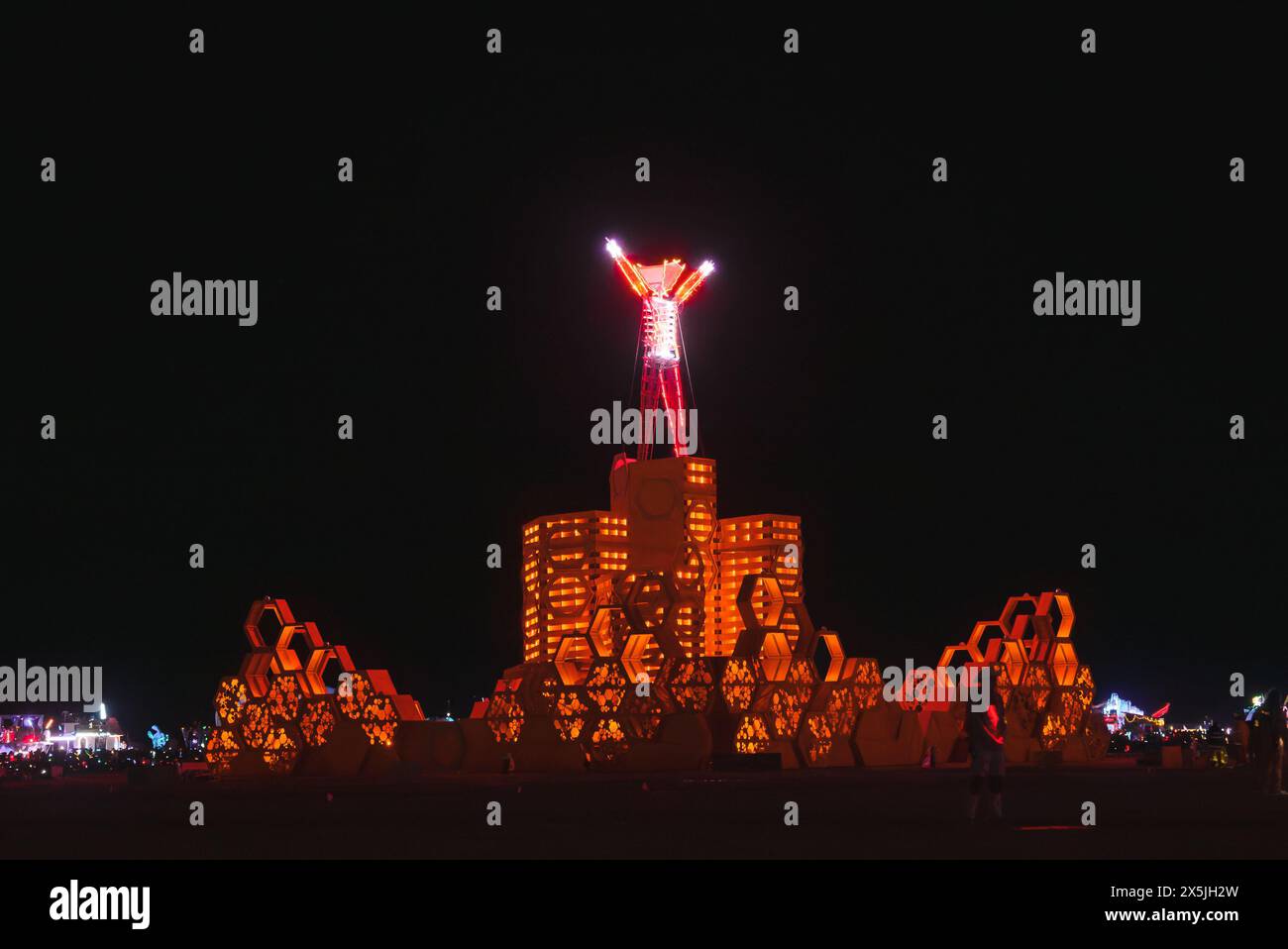 Nighttime desert festival with glowing human figure art installation ...