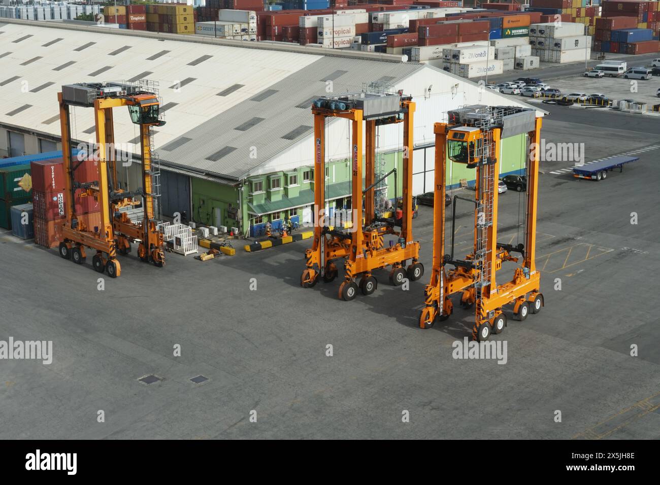 Three orange straddle carriers in Bridgetown container terminal parking ...