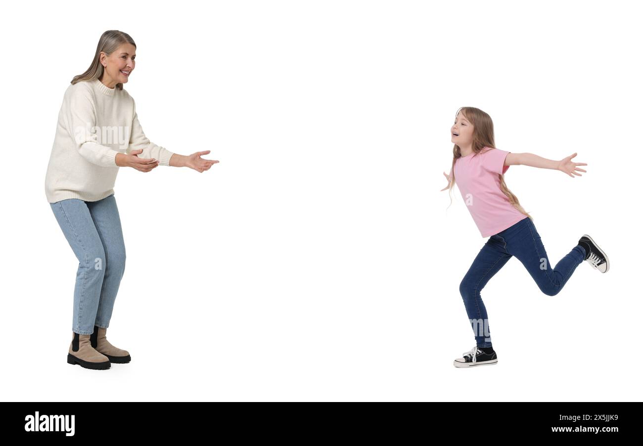 Happy girl running towards her grandmother on white background Stock ...