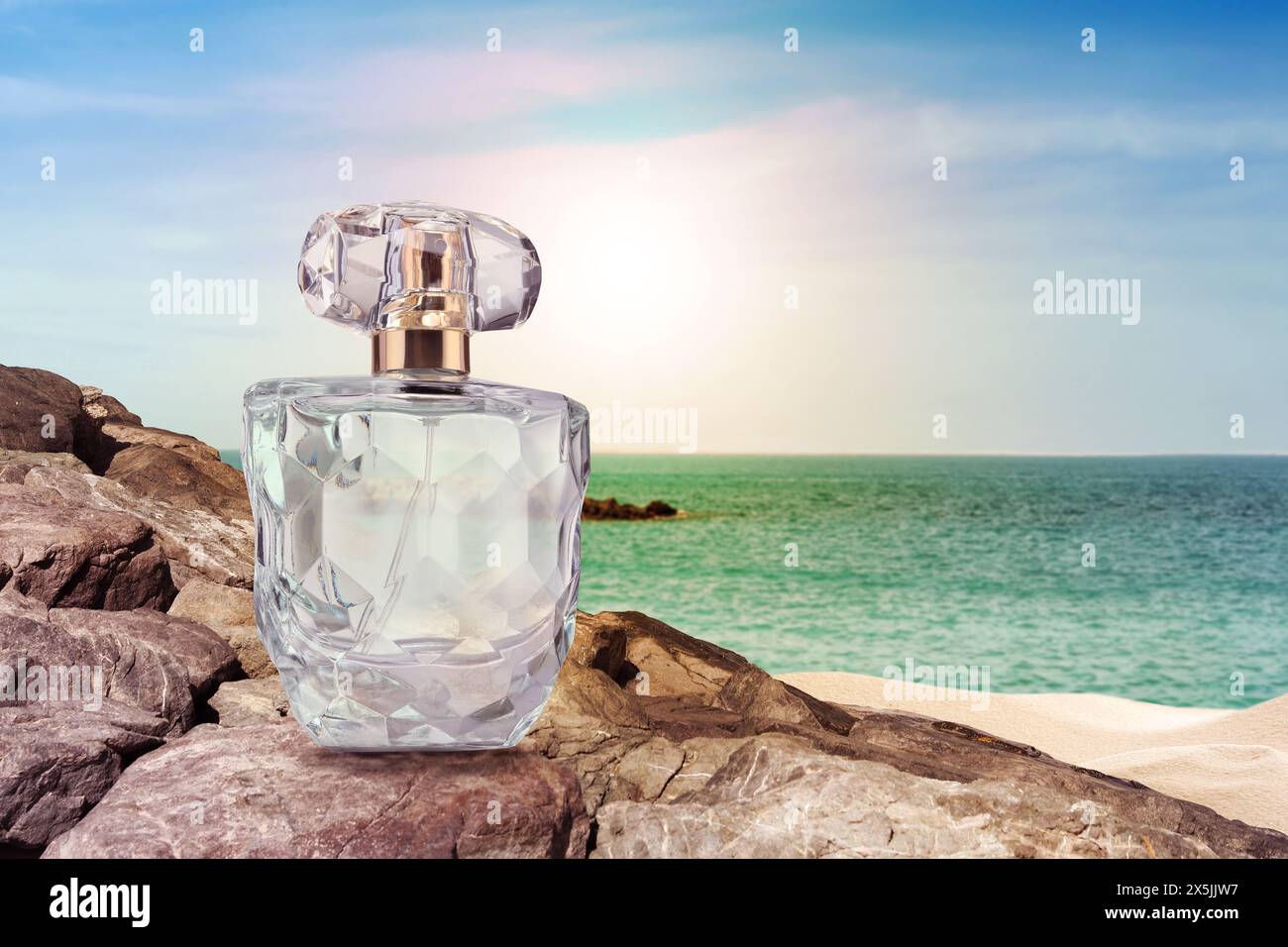 Bottle of aquatic perfume on rock near ocean. Fresh sea breeze scent ...