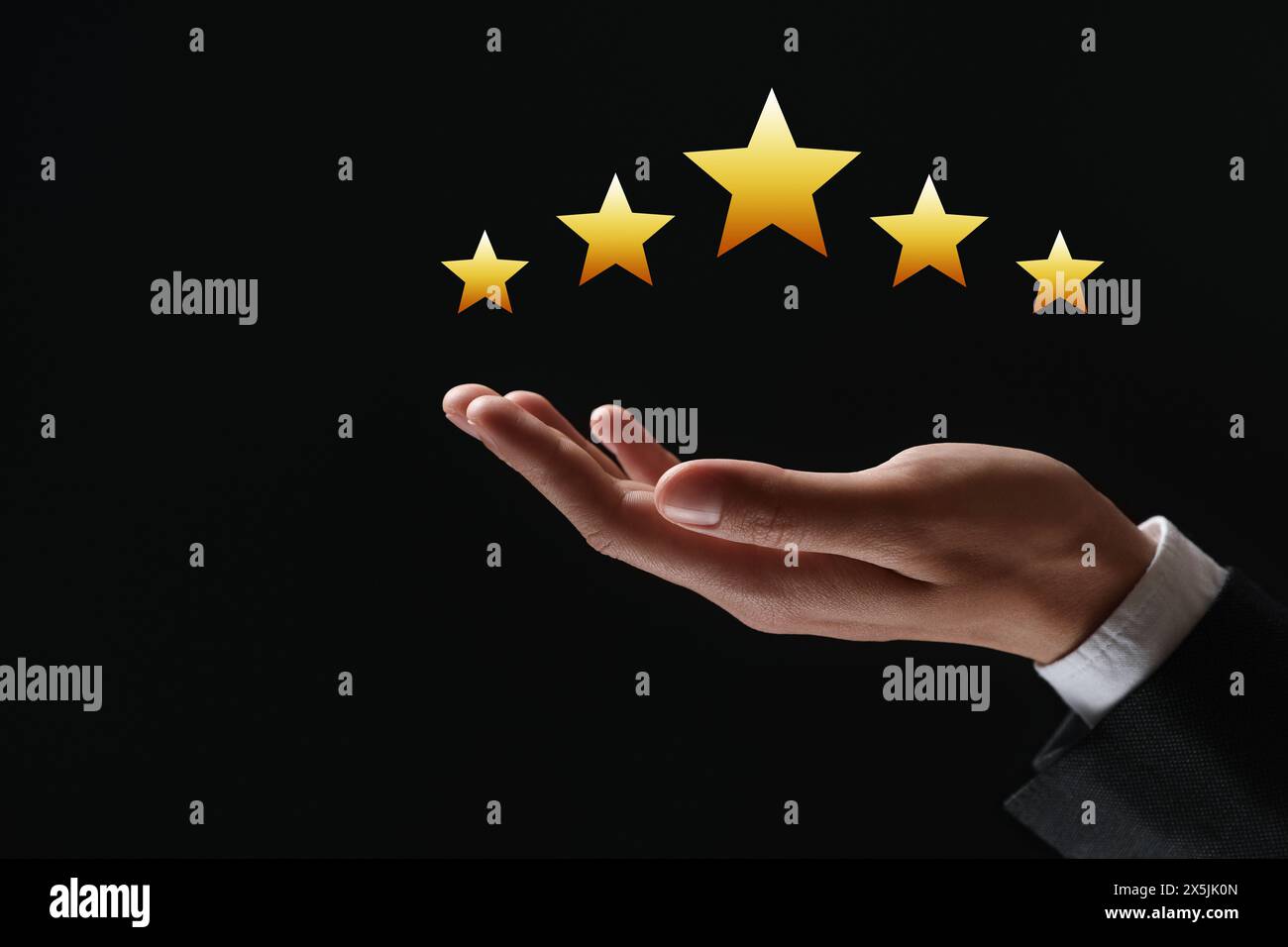 Man holding virtual stars on black background, closeup. Customer ...