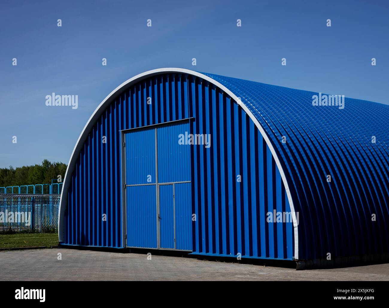 Blue Metal hangar oval against sky. Metal structure of industrial ...