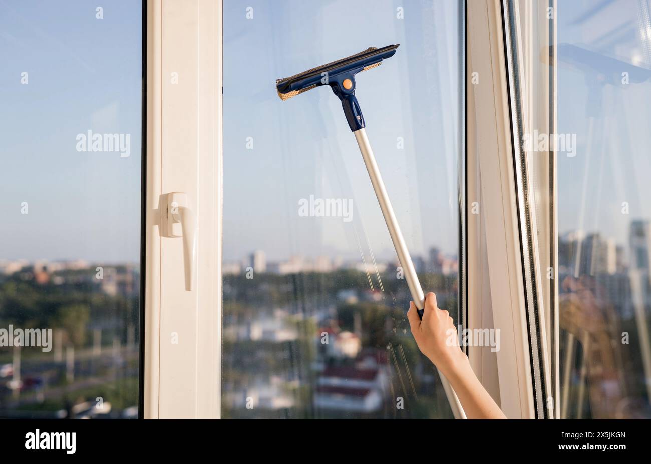 Washing windows theme. Window cleaner using mop to wash a windows ...